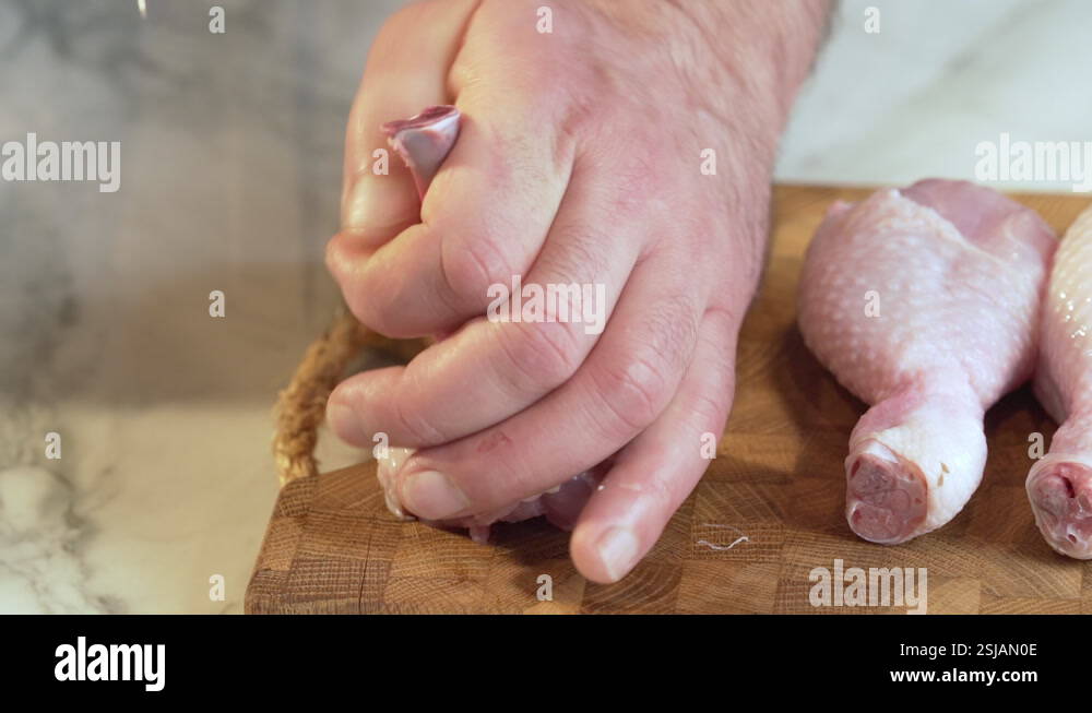 Preparation of the chicken before frying A chef cuts the cartilage off ...