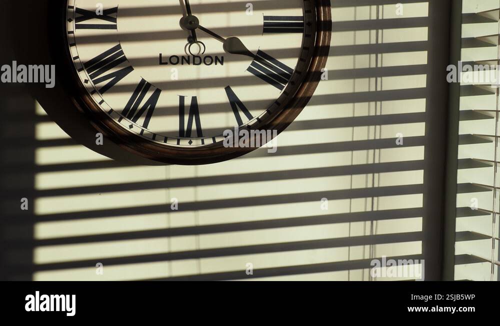 Sunlight patterns on a wall with a clock Stock Video Footage - Alamy