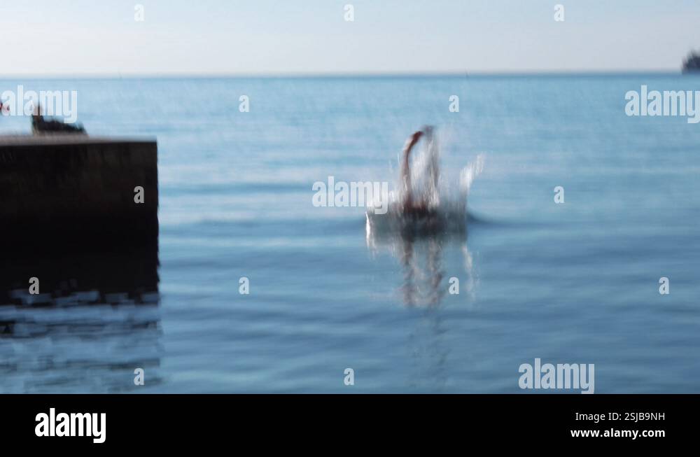 Man demonstrating funny pose jumps from pier into sea water Stock Video ...