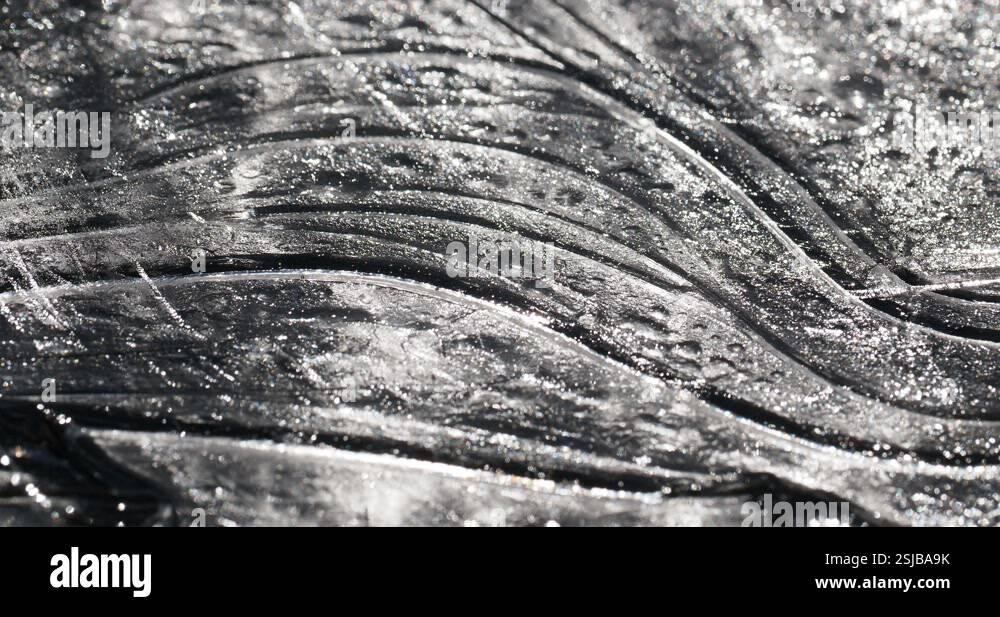 Patterns on ice on a frozen puddle backlit by the sun in Ambleside ...