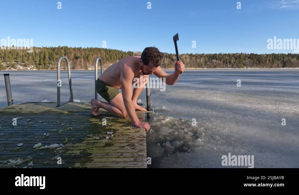 man breaking the ice with an axe to go cold water swimming Stock Video ...