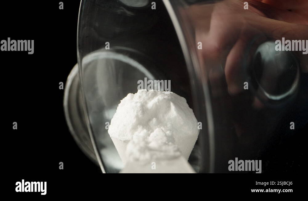 I take a spoonful of white powder out of the jar and pour it into a ...