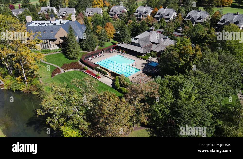 Aerial rotating parallax shot of private pool and clubhouse on golf ...