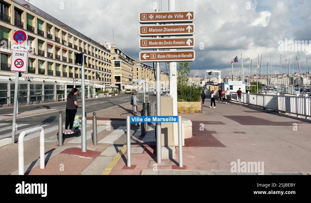 Static view of Ville de Marseille sign and people by sunny old port ...