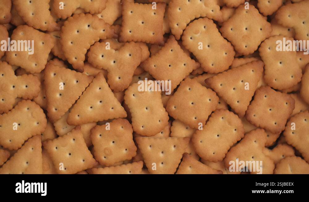 lot of small cracker cookies of different shapes are rotating, closeup ...