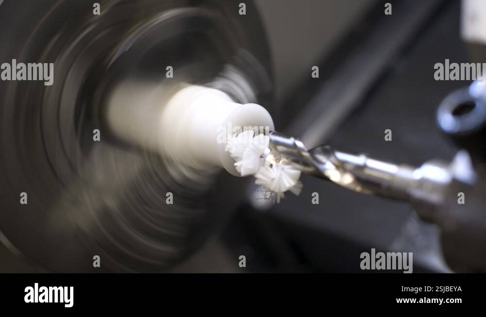 Close-up of an automated lathe making a part from caprolon. Industrial ...