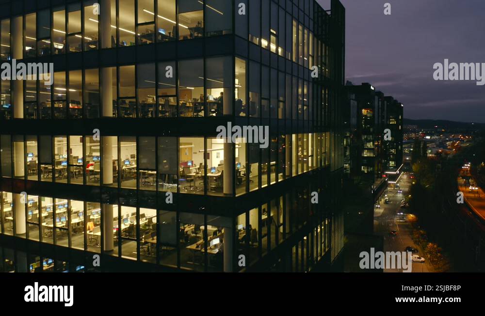 Aerial view of corporate office windows with workers at night Stock ...