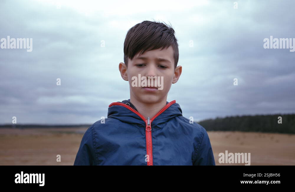 Fiery Gaze: Angry Boy Staring at the Camera Outdoors in Cloudy Weather ...