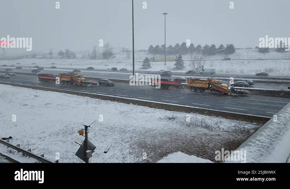 Snowy blizzard like conditions as seen from on top of highway overpass ...