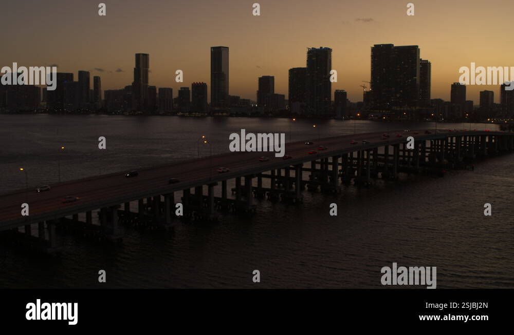 Miami Bridge With Downtown Miami In The Background and cars going by at ...