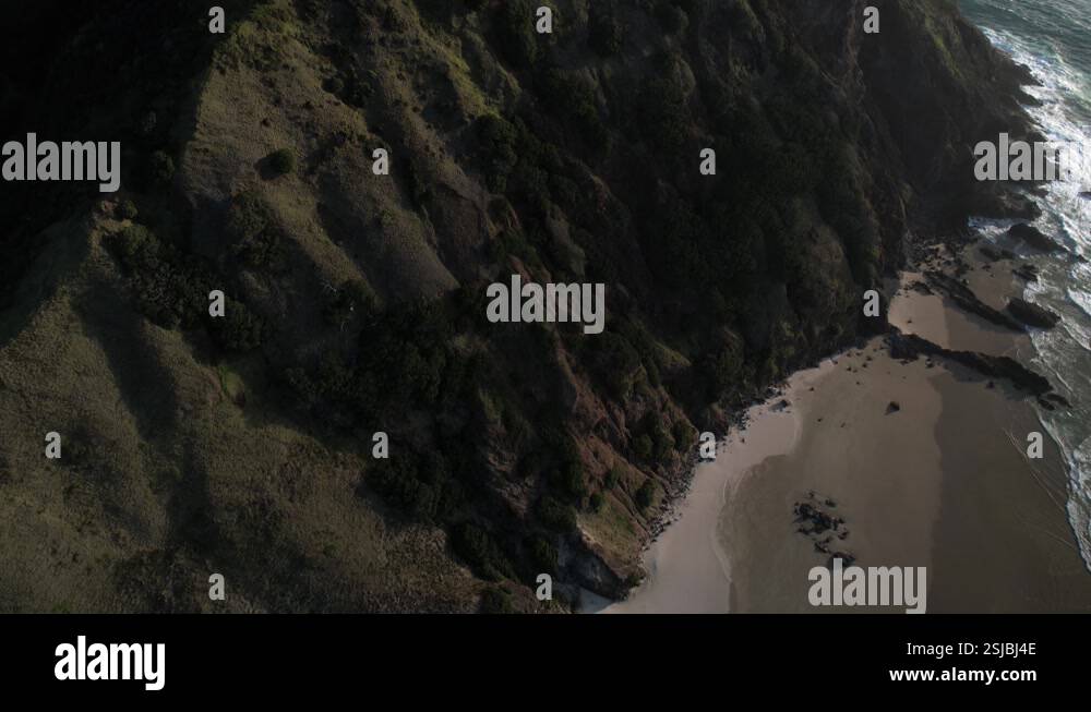 Spectacular view of Cape Reinga Lighthouse over sandy beach reveal ...