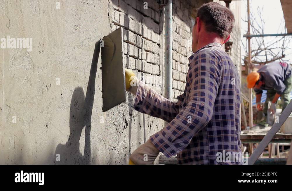 Two Construction Mason Workers Working On a New House External Wall ...