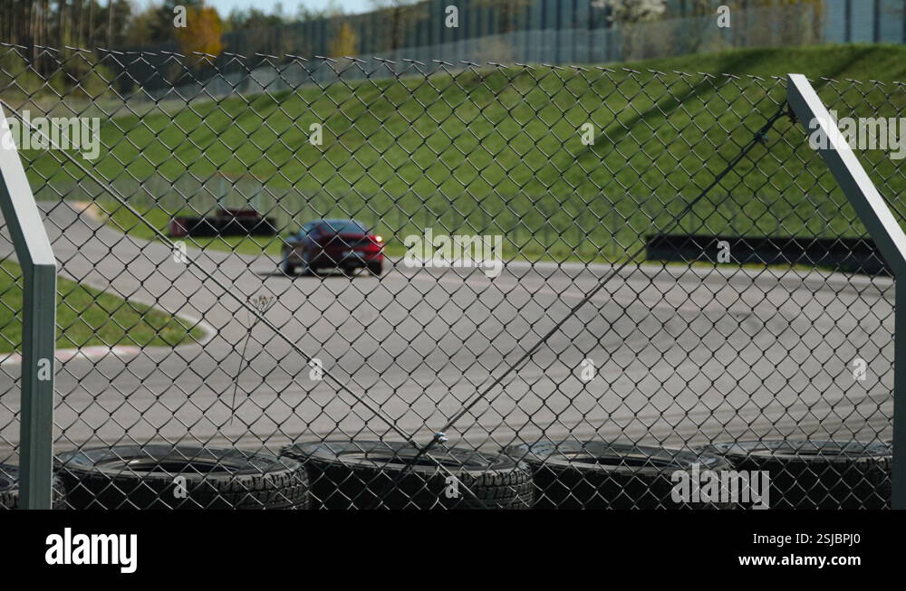 Safety fencing of racing ring track made of mesh and car tires with red ...