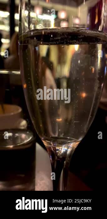 close view of a glass of champagne through which you can see the ...