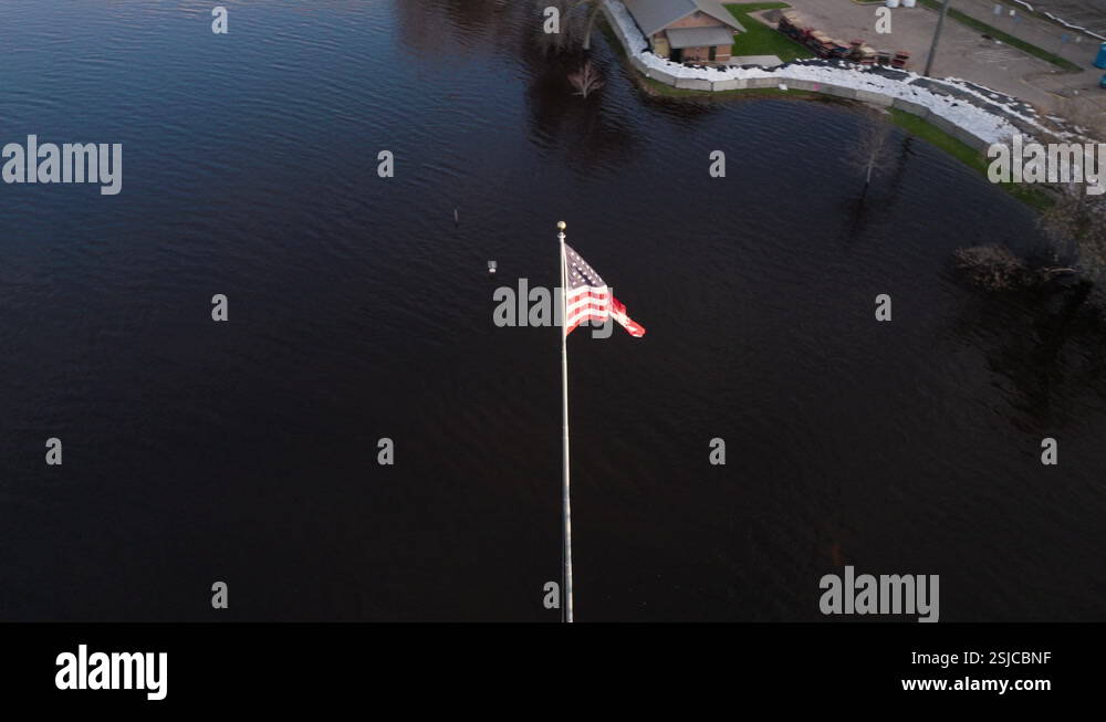 American flag pole underwater during severe flooding with sandbag ...