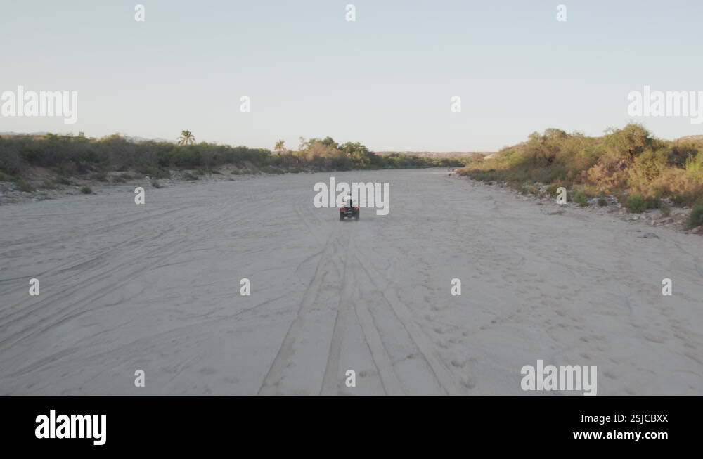 Man riding a motorcycle lifting a dust trail behind him. Dry and dusty ...
