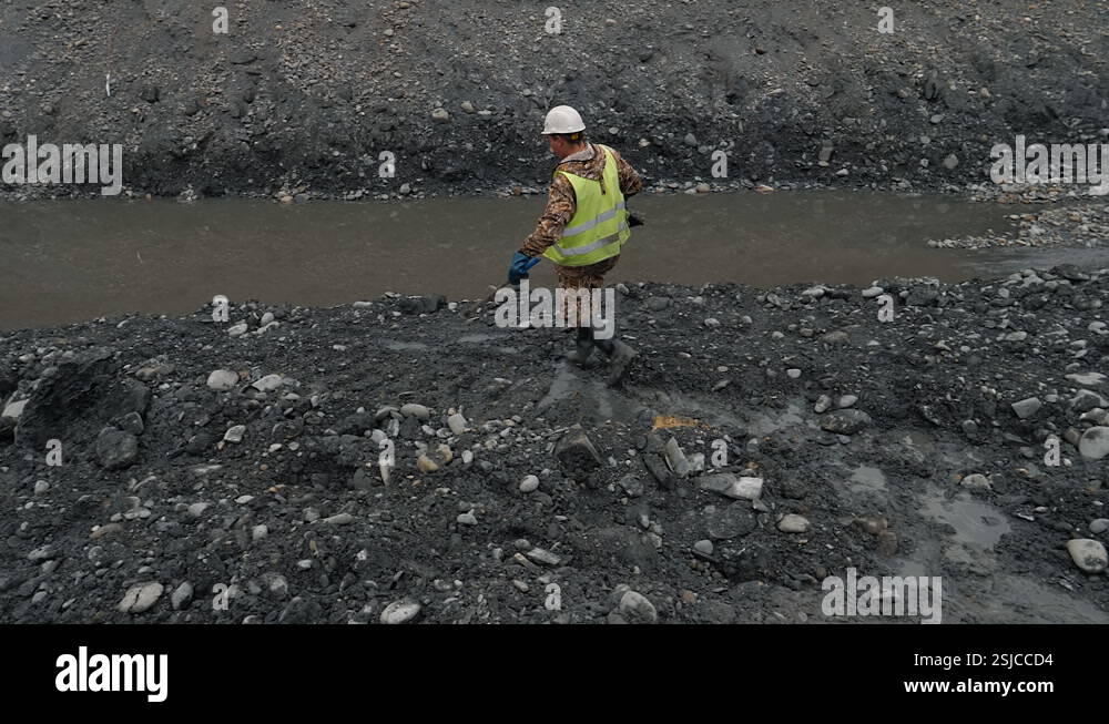 Surveyor worker searching for valuable gold metal deposits at the open ...