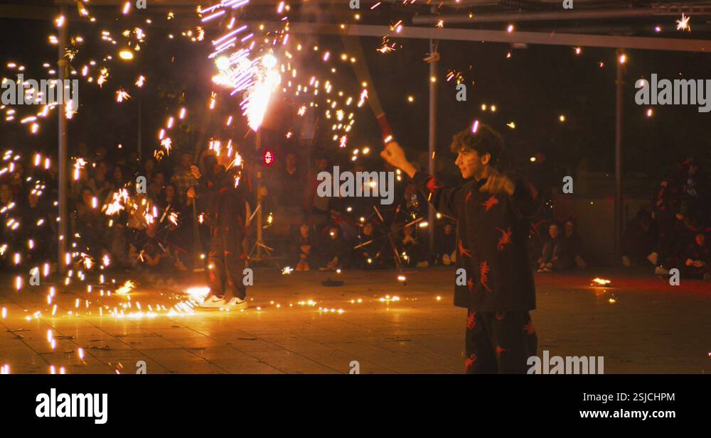 Pyrotechnic show. Two guys in black costumes perform a dance with fire ...