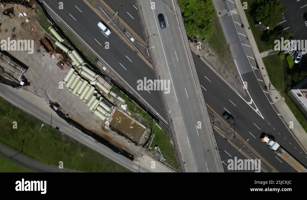 An aerial view directly over a highway intersection with areas of green ...