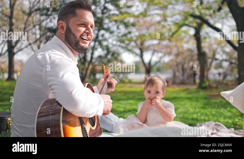 Little girl eating snacks from a charcuterie board during a picnic on a ...