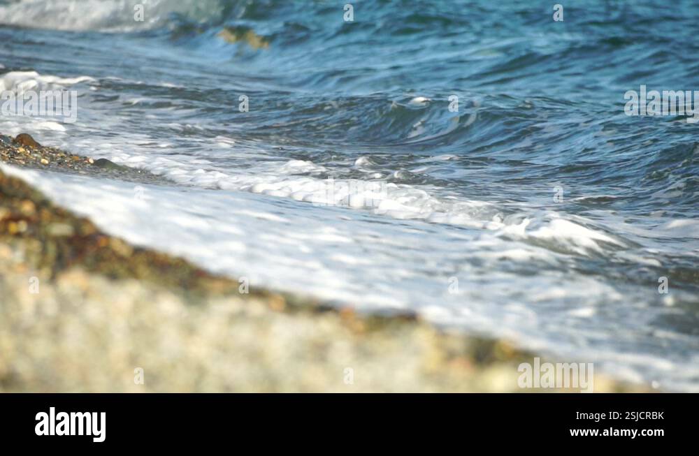 Small sea wave, Blurred Soft foamy waves washing golden pebbled beach ...