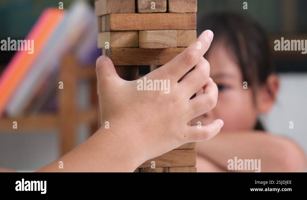 Cute Asian siblings having fun playing Jenga together. Two children ...