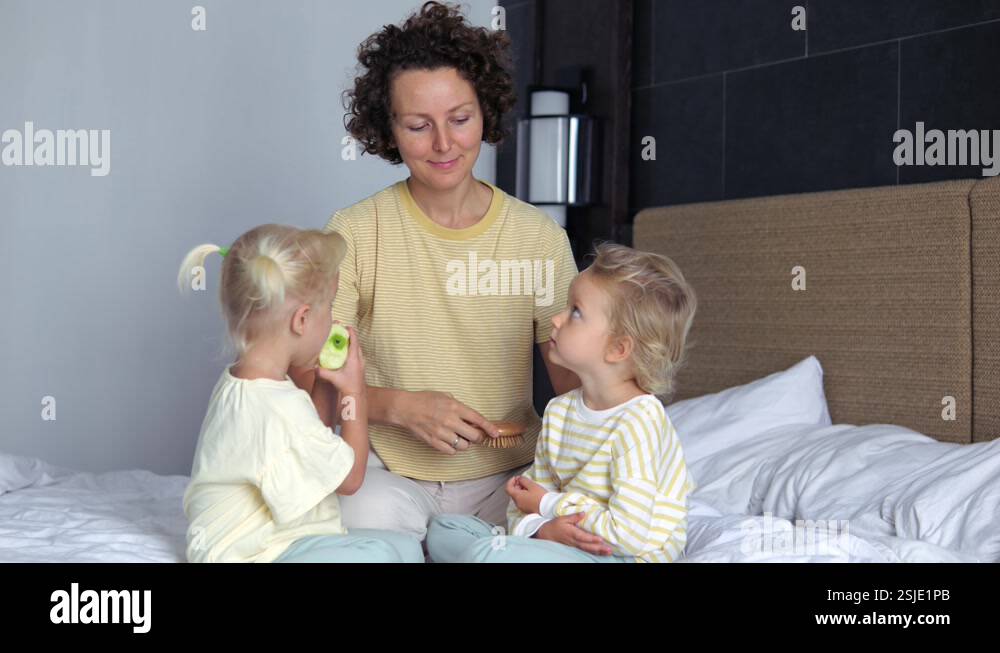 Loving, sweet, caring mother of two daughters smiles happily combs her ...