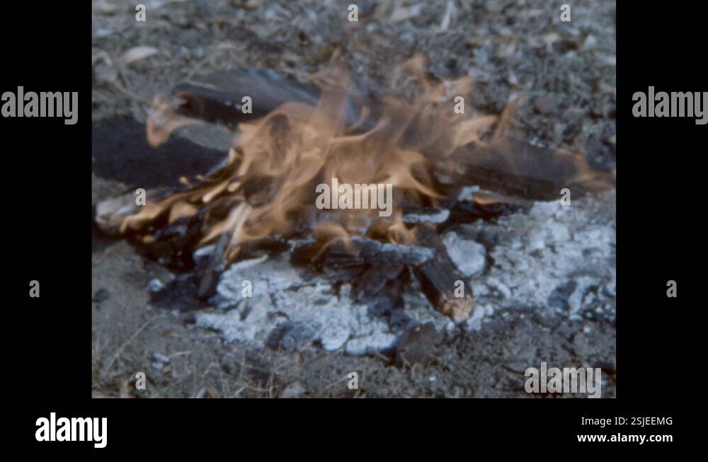 1950s: A campfire with wood planks burns. In fire, pieces of wood ...