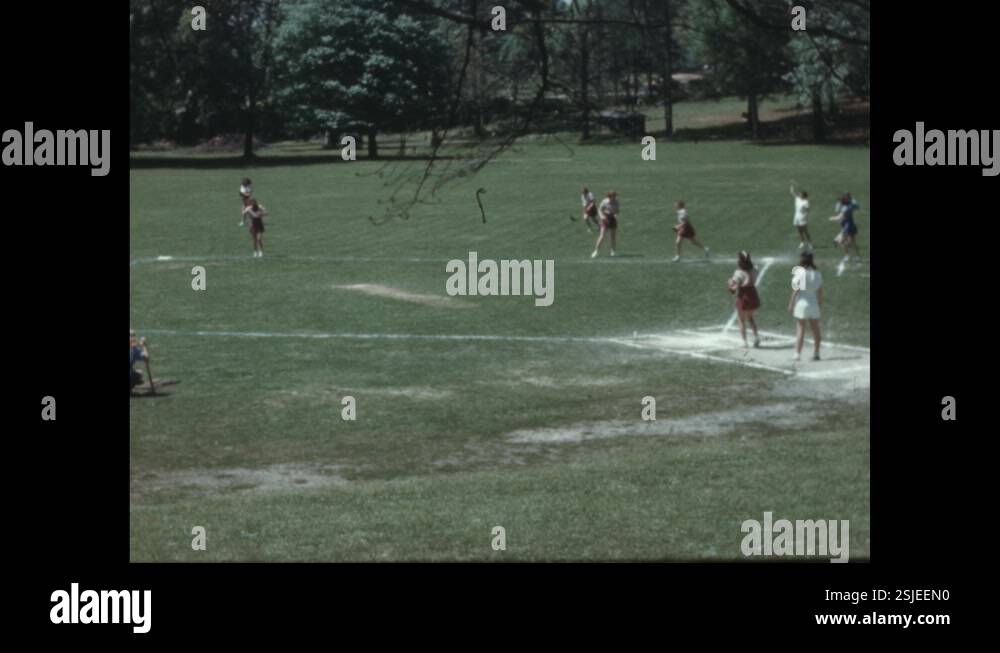 1940s: Teams switch places on softball field. Audience claps and cheers ...