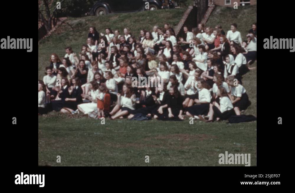1940s: Audience claps and cheers. Teams switch places on softball field ...