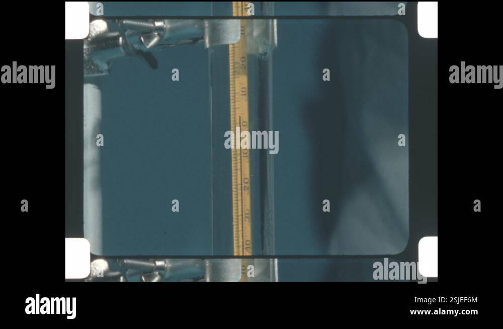 1960s: Person in lab coat sticks long thermometer into test tube of ...