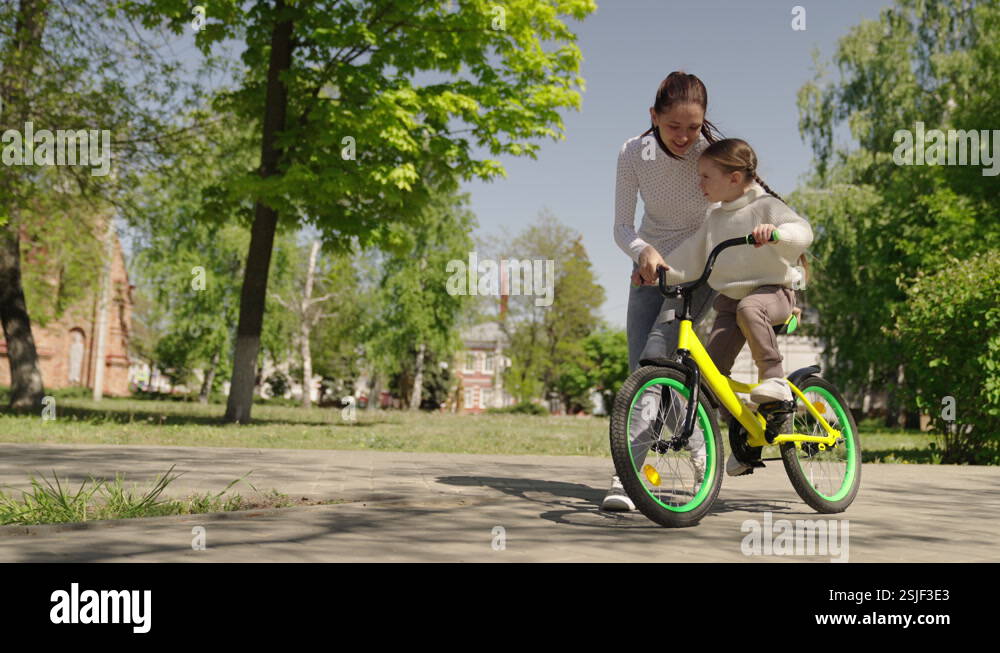riding child bike road. happy family moments mother daughter park ...