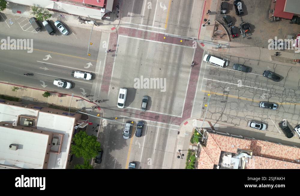 Top down circling aerial above four way intersection on main street in ...