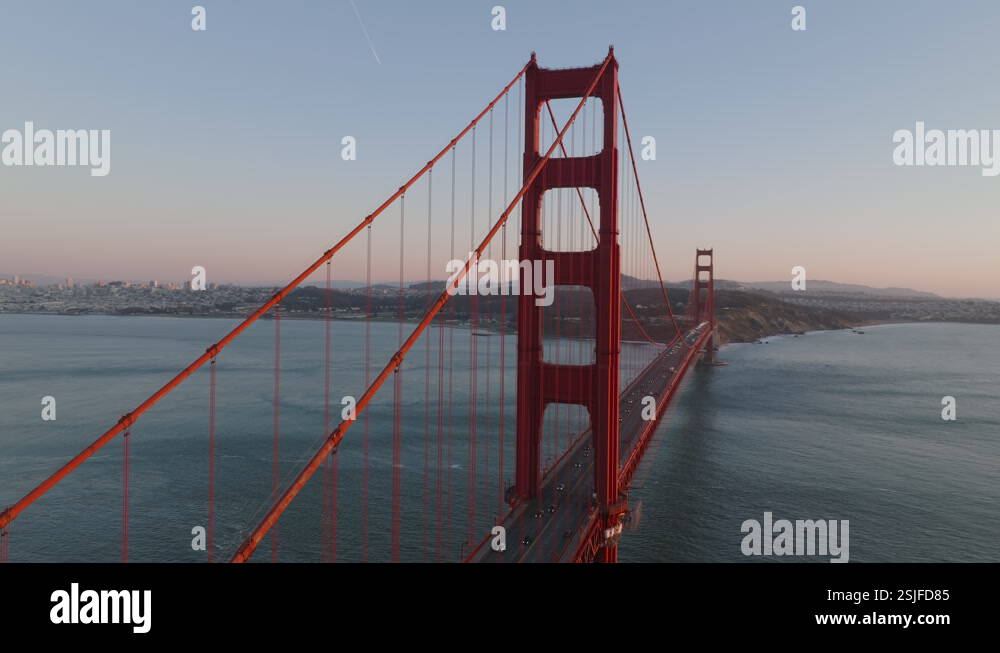 Aerial slide and pan footage of long suspension bridge over strait ...