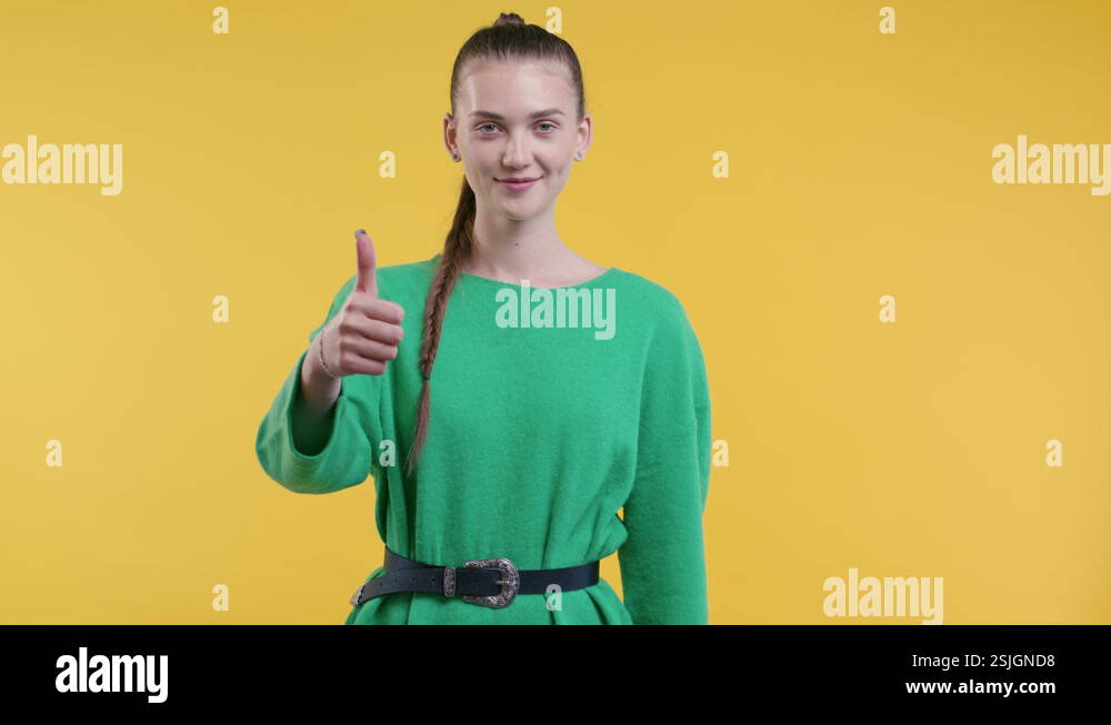 Smiling teenage girl, hand sign like,thumbs up gesture.Lady on yellow ...