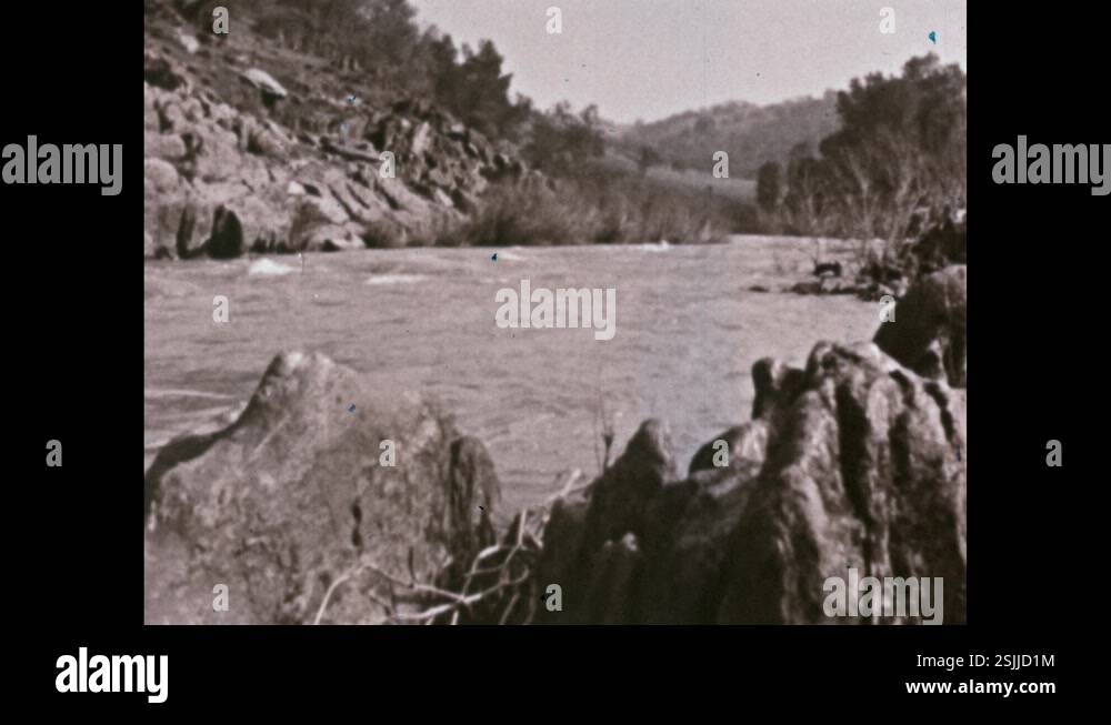1950s: River flows. Different rivers. Man and boy sit talking. River ...