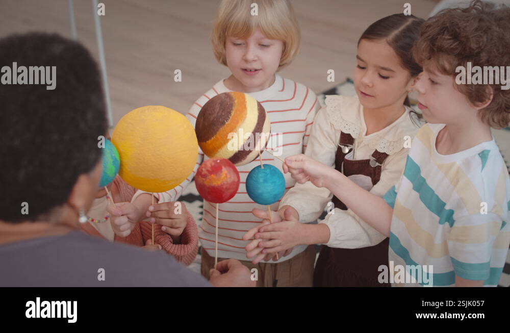 School Kids with Reacher Looking at Handmade Planets of Solar System ...
