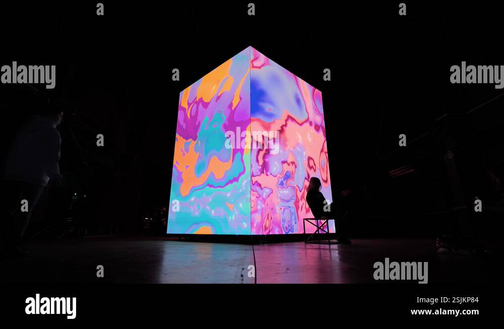 People moving in front of AR display cube with mirror effect ...