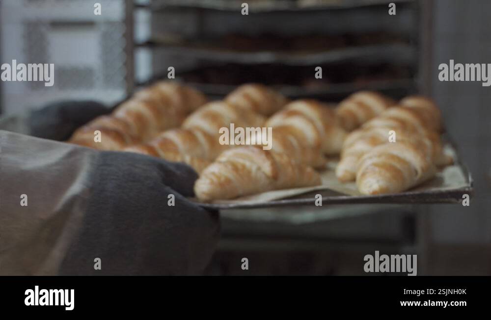 fish crossatints are pushed on a tray into a trolley in a bakery Stock ...