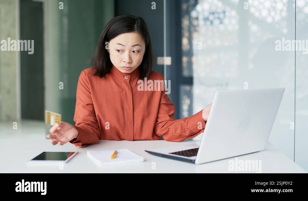 Sad asian businesswoman detected fraud by typing credit card number on ...