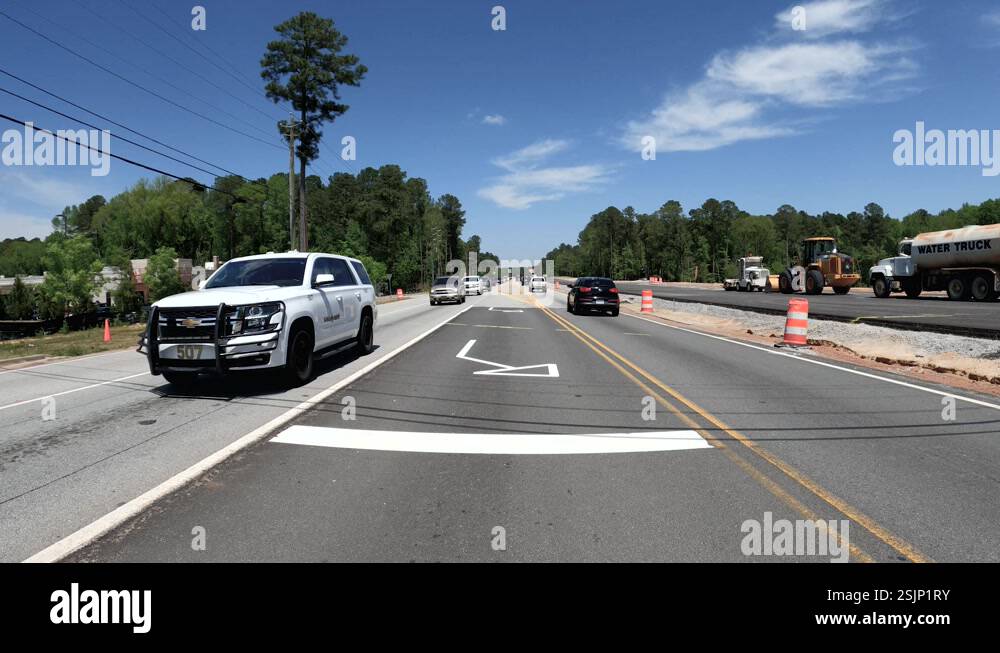 Rear POV FPV driving turning onto a side road clear blue sky road ...