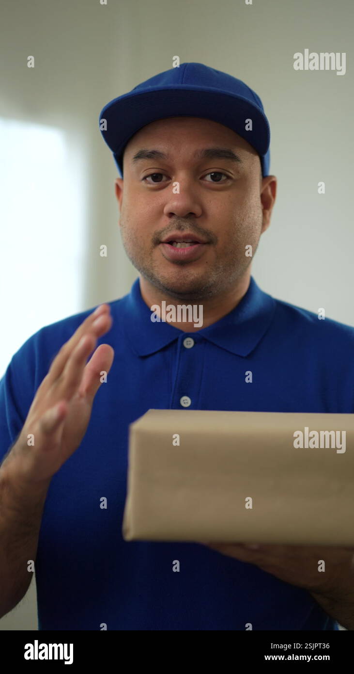 Vertical shots of portrait delivery man in blue uniform holding box ...