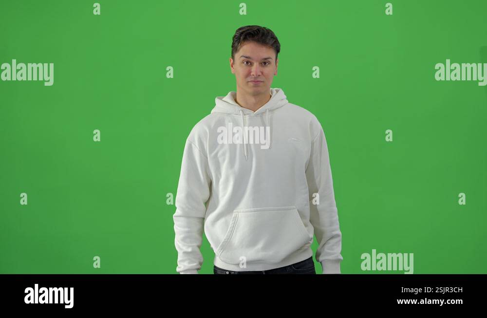 Handsome young man smiles at the camera in a green screen studio Stock ...