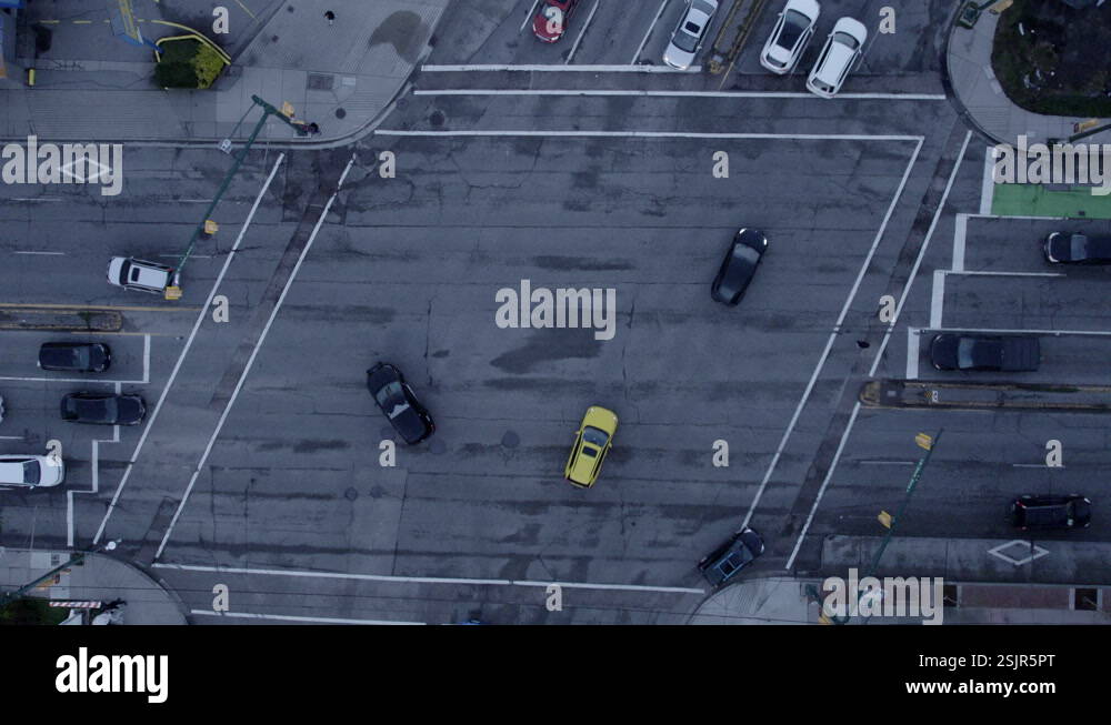 Birds eye view of traffic driving through and turning on city ...