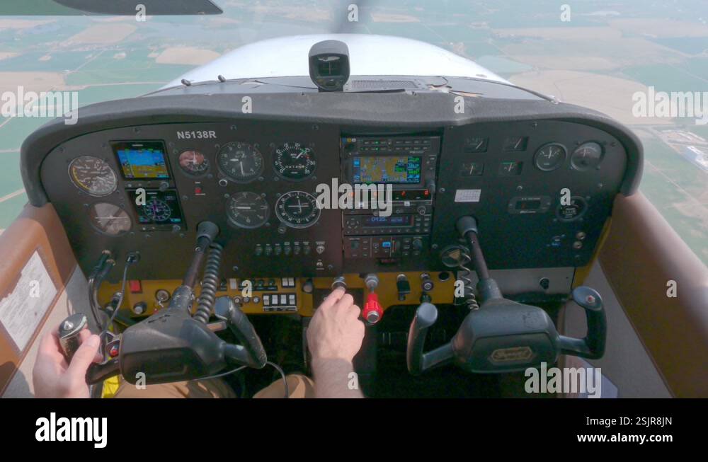 Top down view of the cockpit of a Cessna 172, with the pilot reaching ...