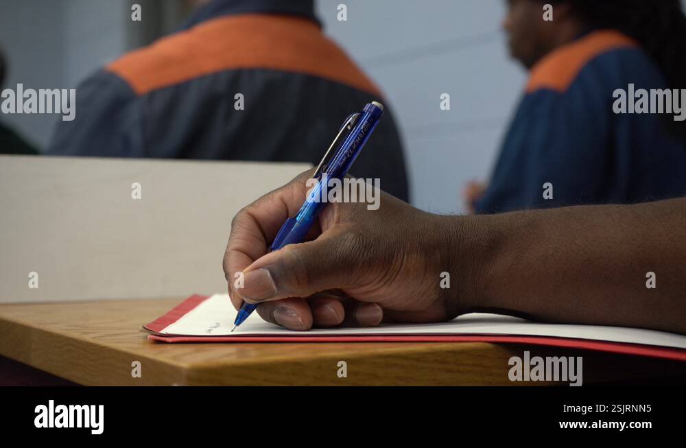 close up african american writing in prison black inmate in jail ...