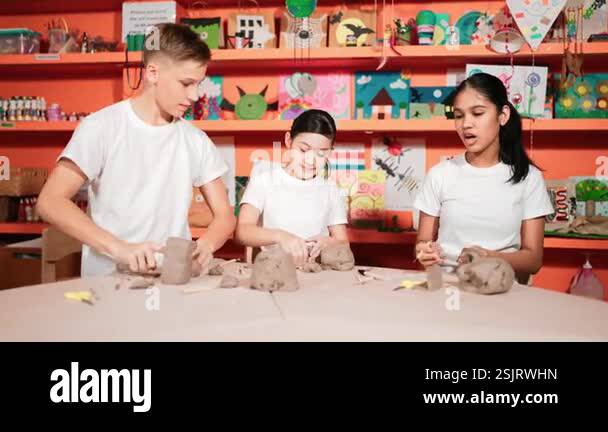 Smart boy pick clay while looking though hole at pottery workshop ...