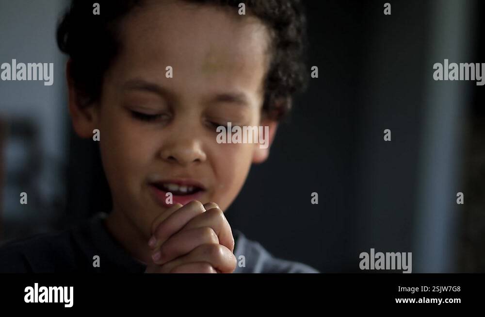little boy praying to God with hands together on white background with ...