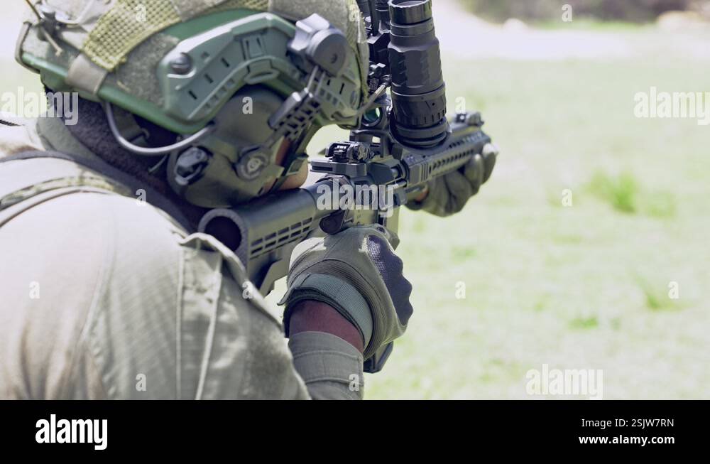 Tactical team soldier practicing shooting at a firing range, on a sunny ...
