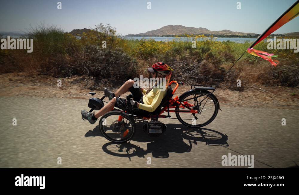 Side view of elderly senior woman riding recumbent e-bike electric ...